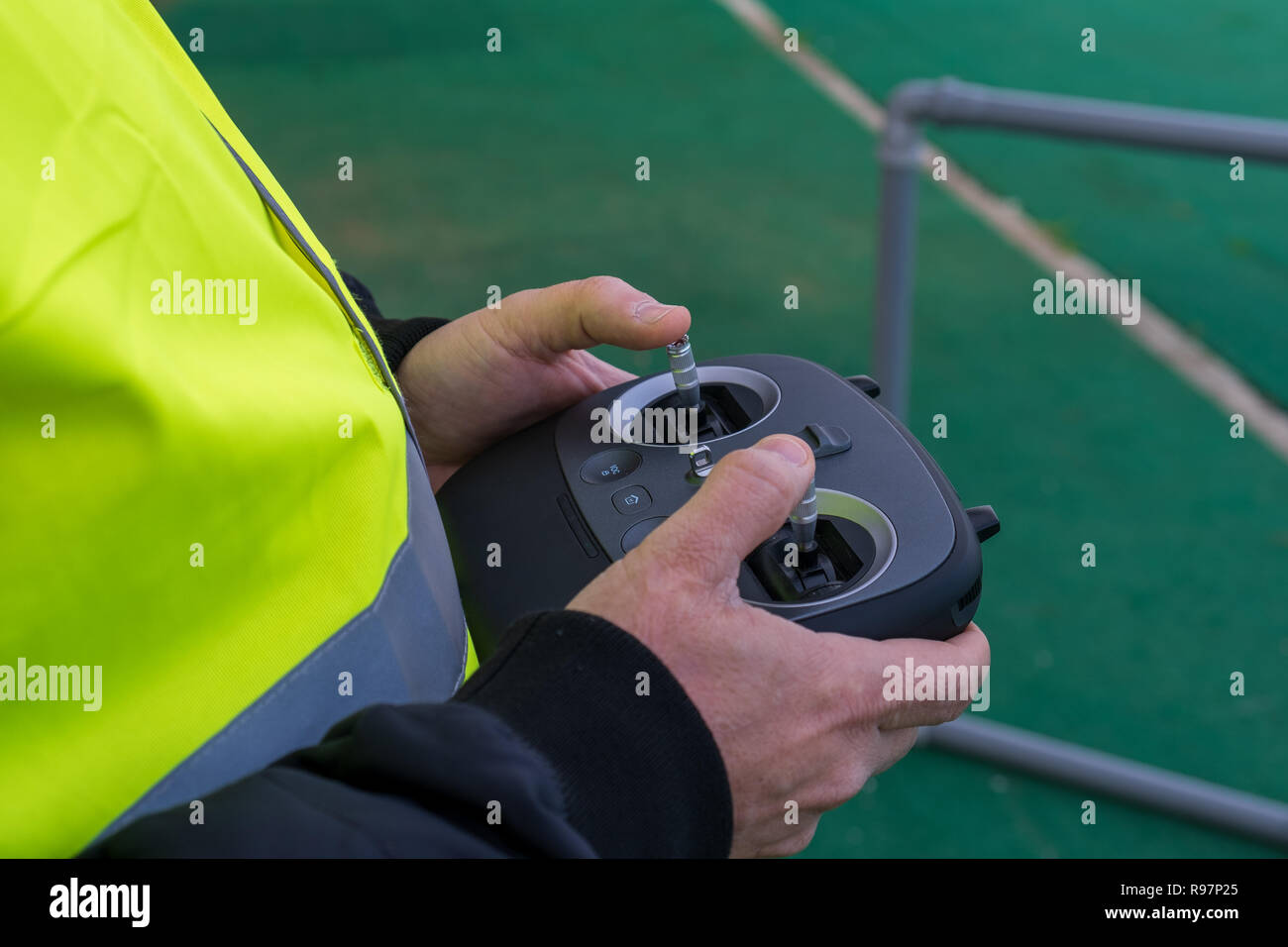 Drone pilot during an exercise wearing a yellow jacket. Pilot pilot ...