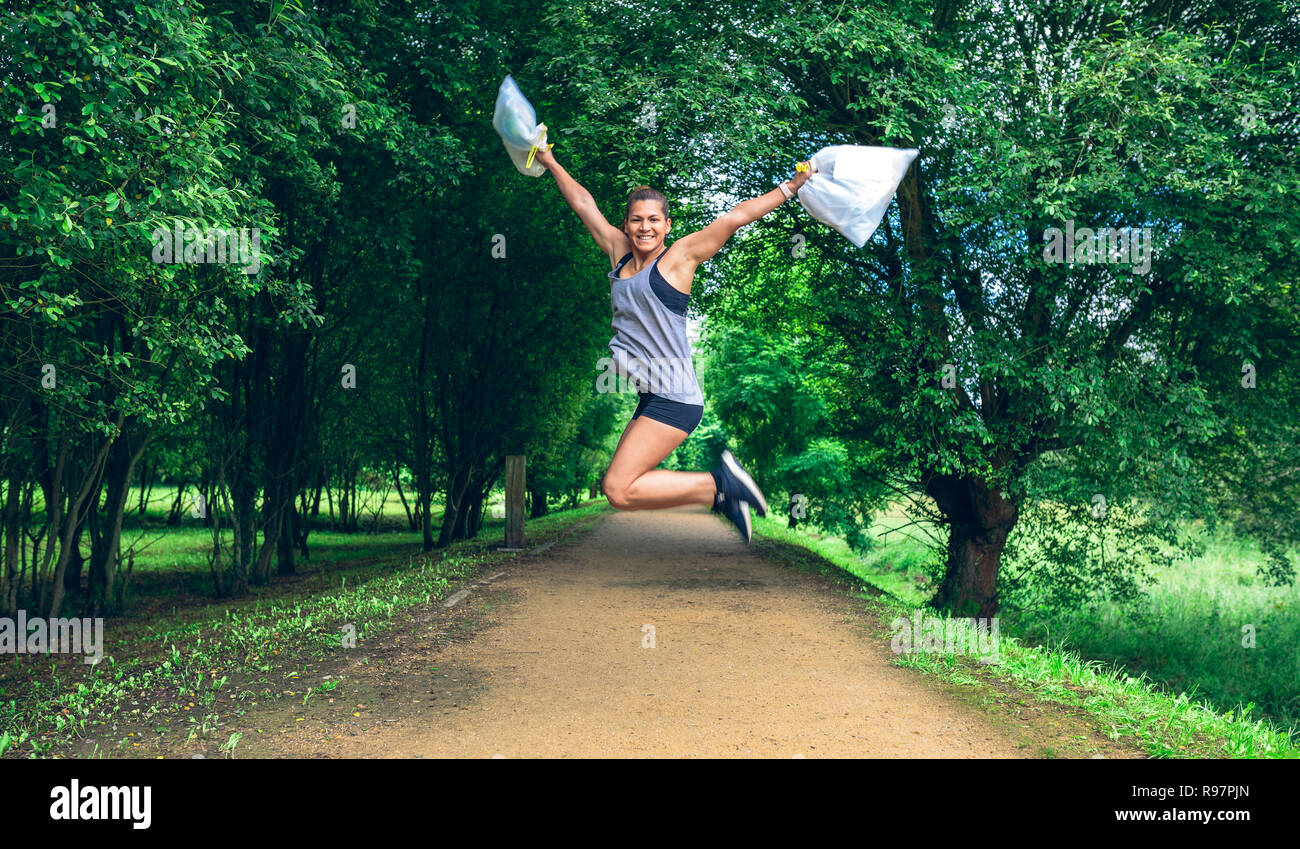 Girl jumping with trash bags after plogging Stock Photo - Alamy