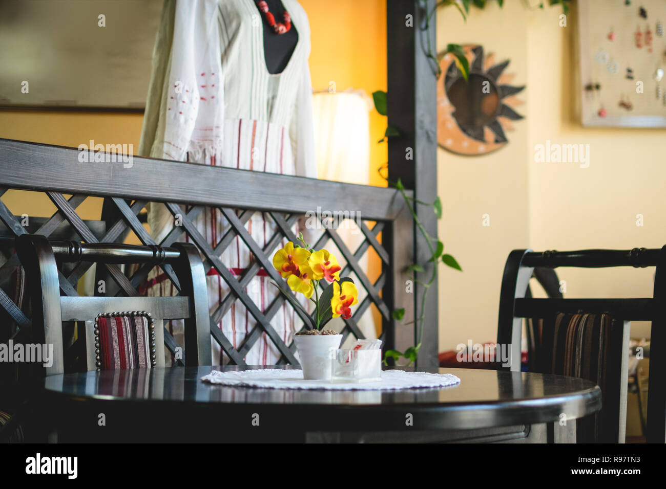 dark color table with two chairs and yellow flowers in the middle and ...