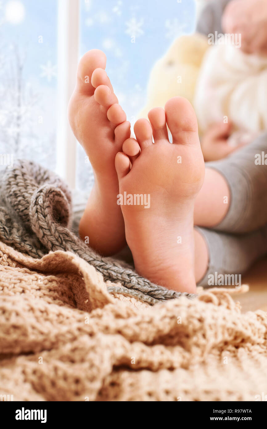 Child's foots are on a window sill with wool plaid and yarns Stock ...