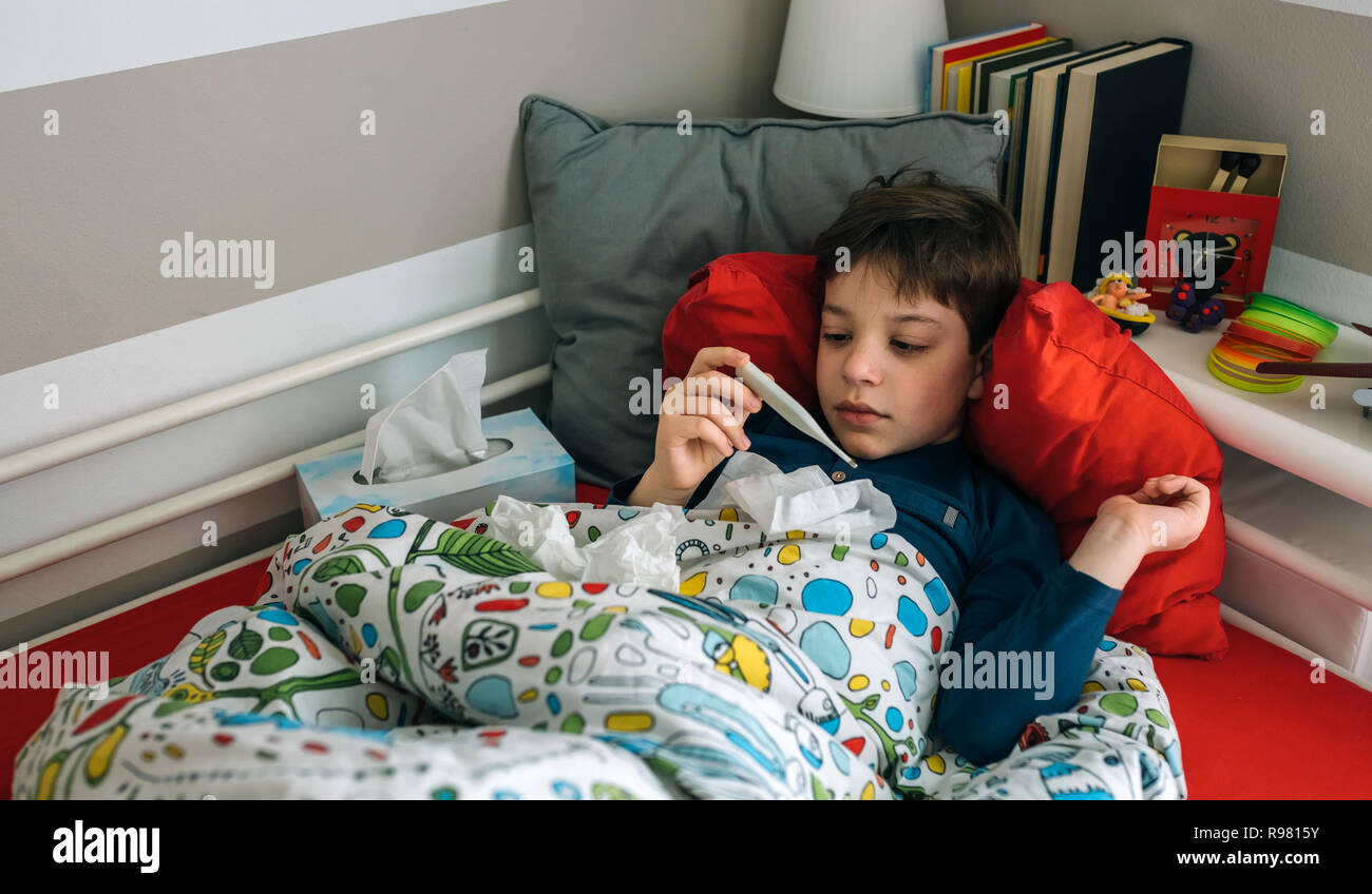 Cold child looking at the thermometer Stock Photo - Alamy