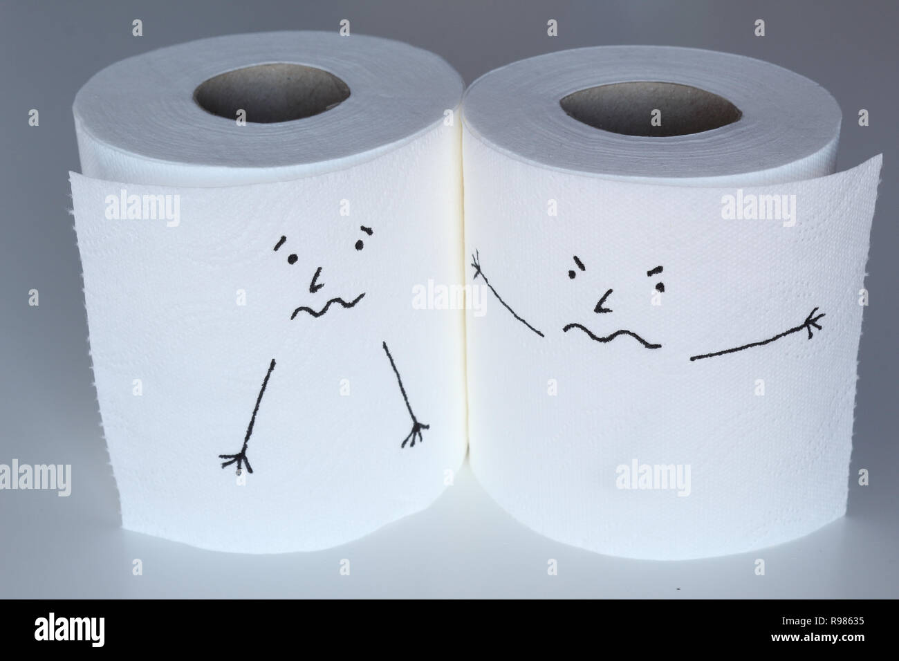 Two white toilet paper rolls sketched with a scared and a angry face ...