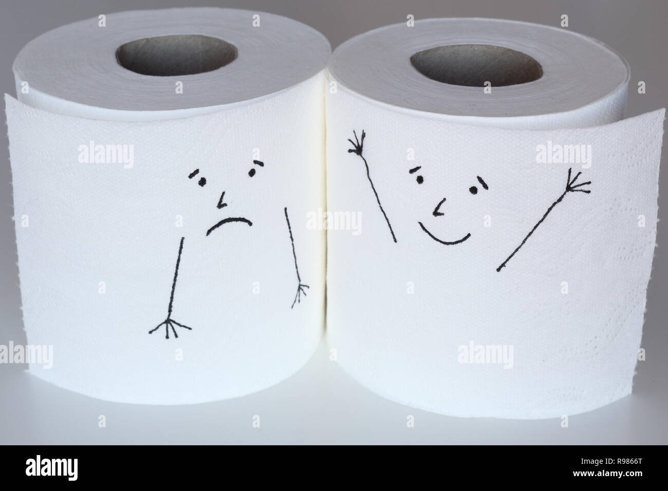 Two white toilet paper rolls sketched with a sad and a cheerful face ...