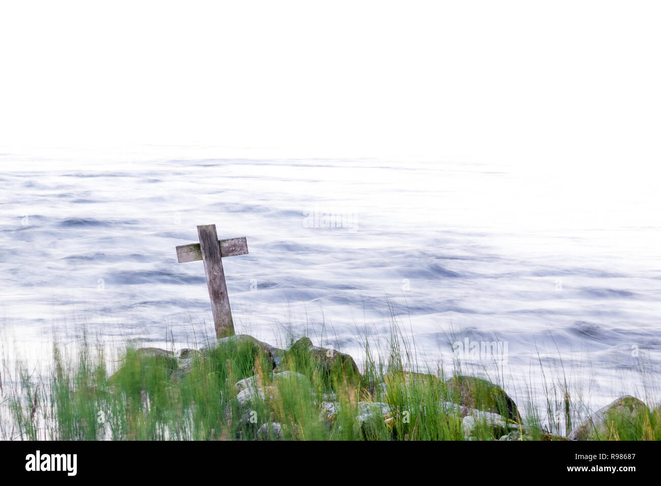 Wooden cross on a lake shore with white background Stock Photo - Alamy