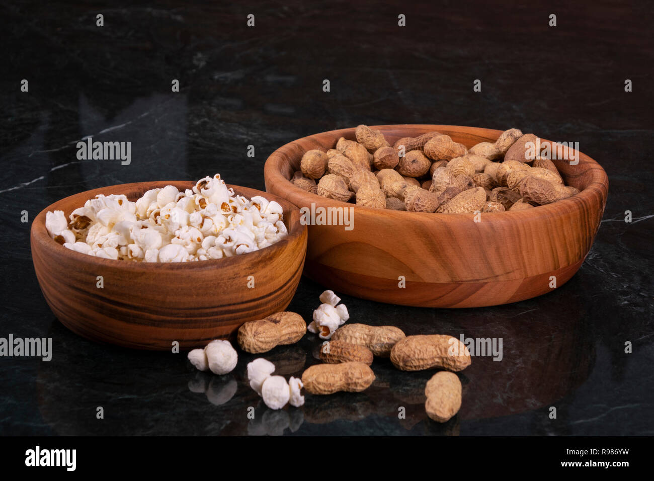 Peanuts with Popcorn in golden wood bowl on black marble table Stock ...