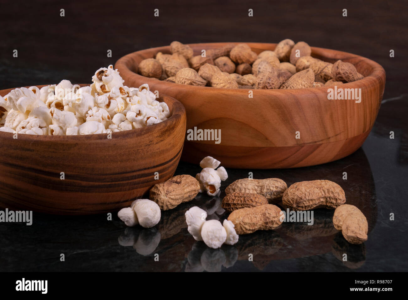 Peanuts with Popcorn in golden wood bowl on black marble table Stock ...