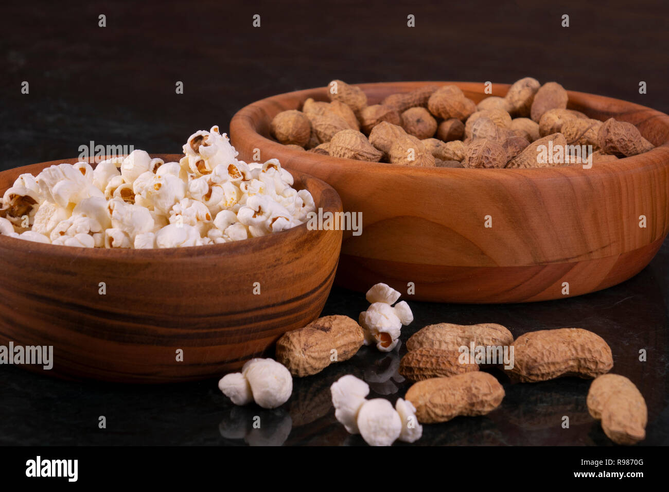Peanuts with Popcorn in golden wood bowl on black marble table Stock ...