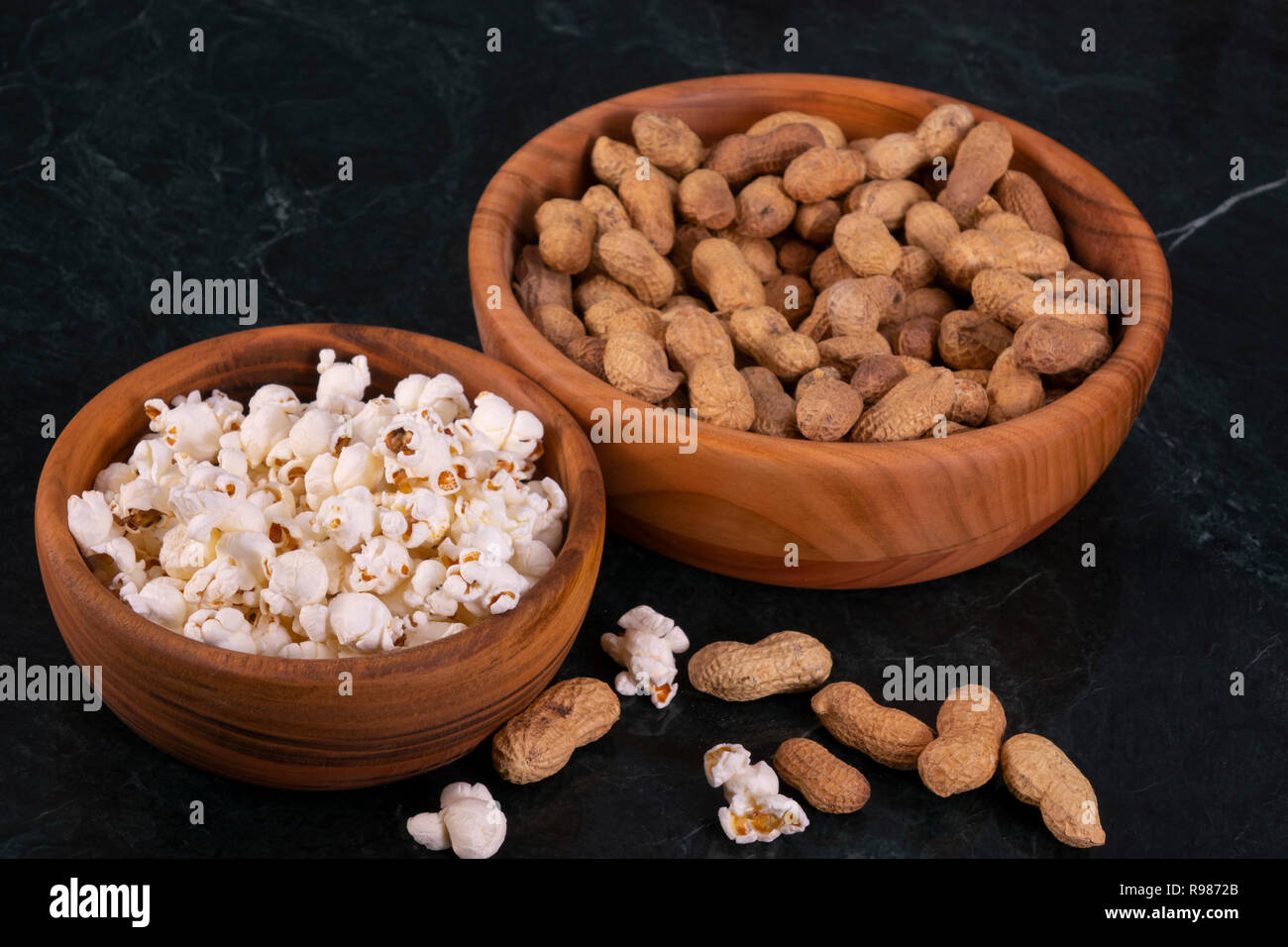 Peanuts with Popcorn in golden wood bowl on black marble table Stock ...