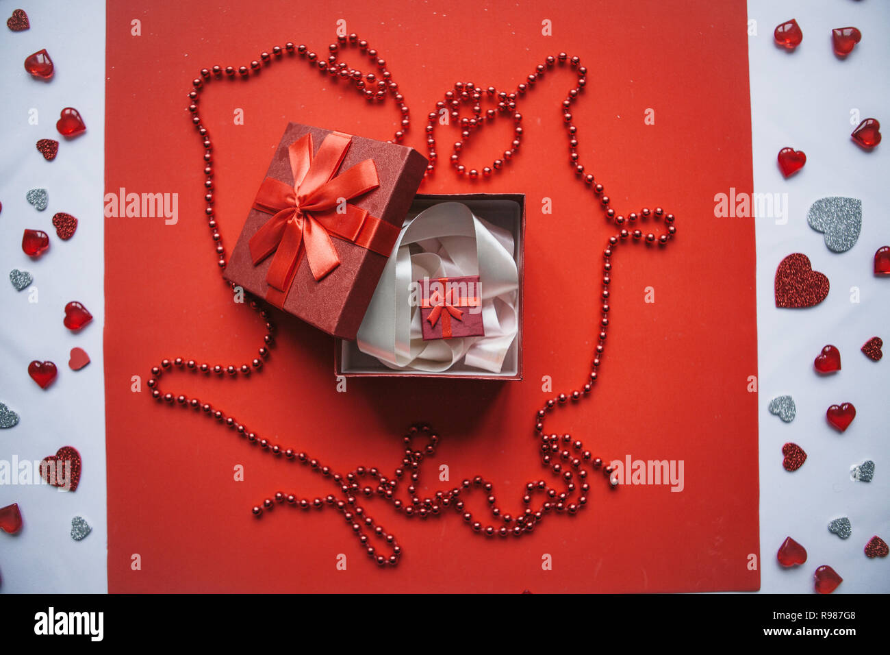 The red box and inside it is another small box with a gift on a red ...