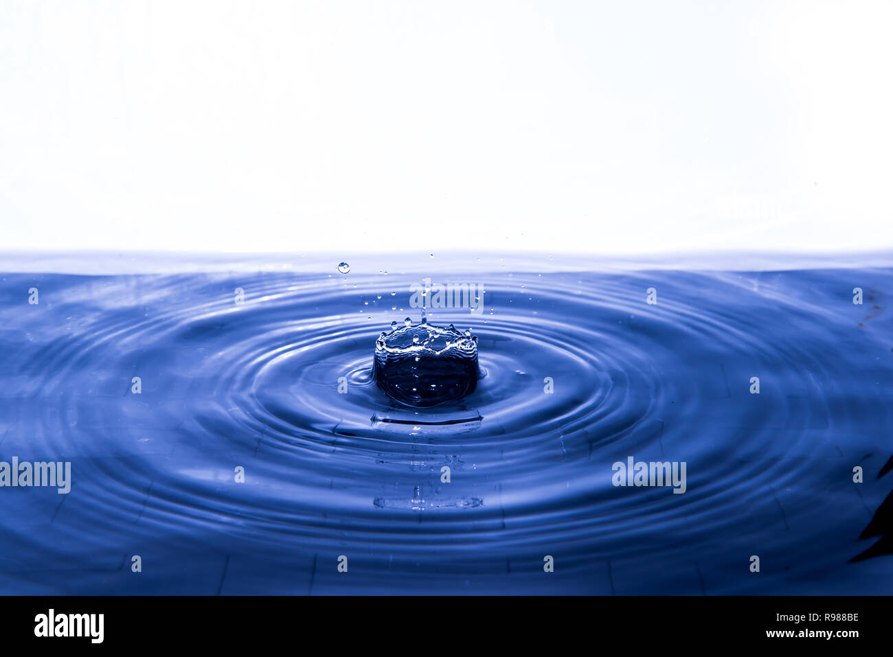 Water drop falling into water making a concentric circles Stock Photo ...