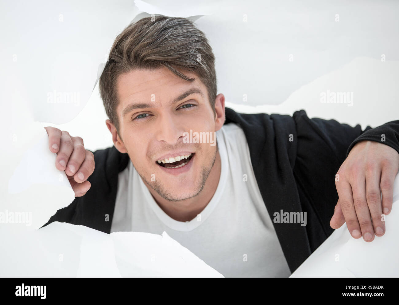 young businessman breaking through a paper wall Stock Photo - Alamy