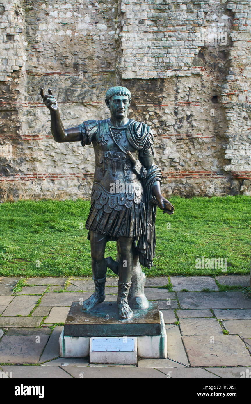 Statue of the Roman Emperor Trajan, outside a section of the Roman wall ...