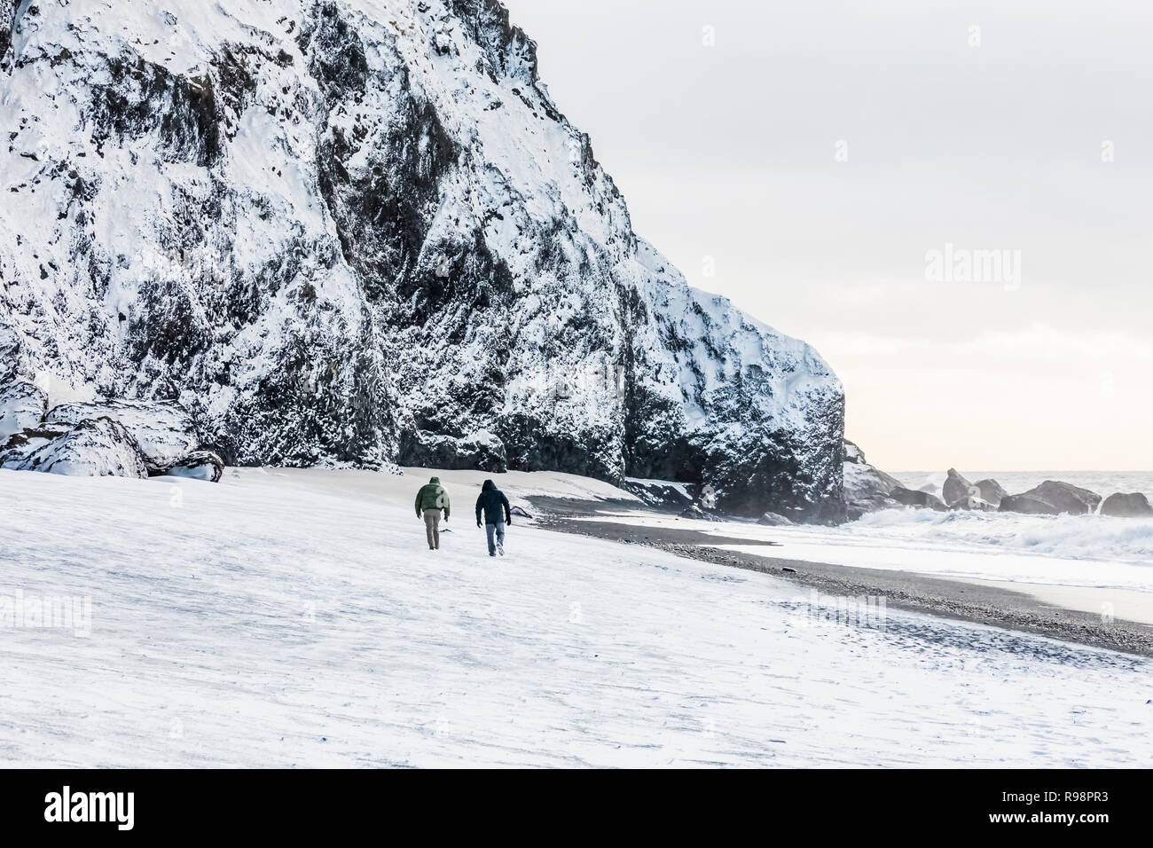 Tourists braving the intense, gale force winds along the Reynisfjara ...