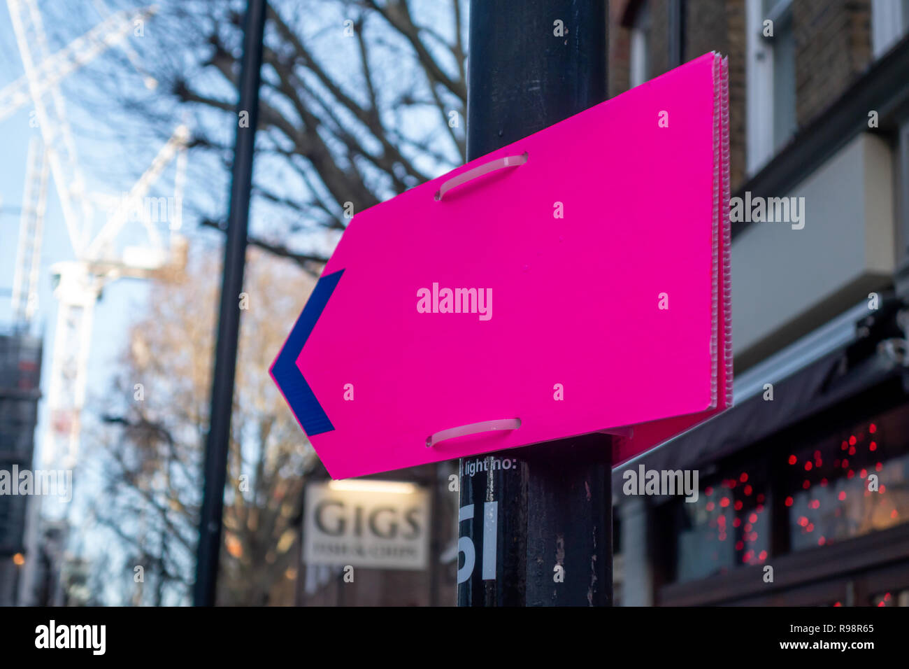 Plastic Purple directional arrow sign fastened to a lamp post with ...