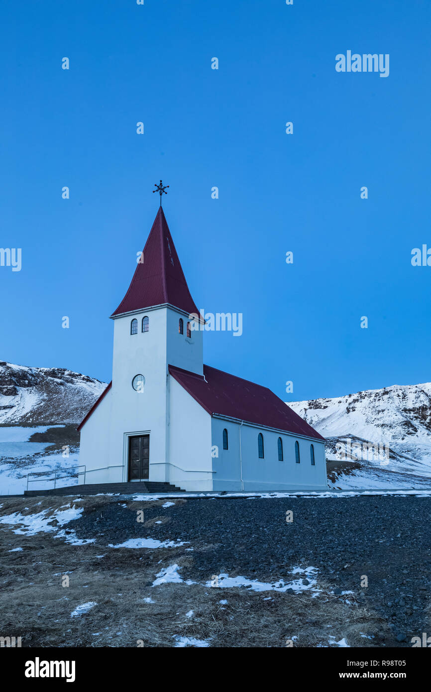 The Vik Church stands dramatically over the town of Vik, at twilight in ...