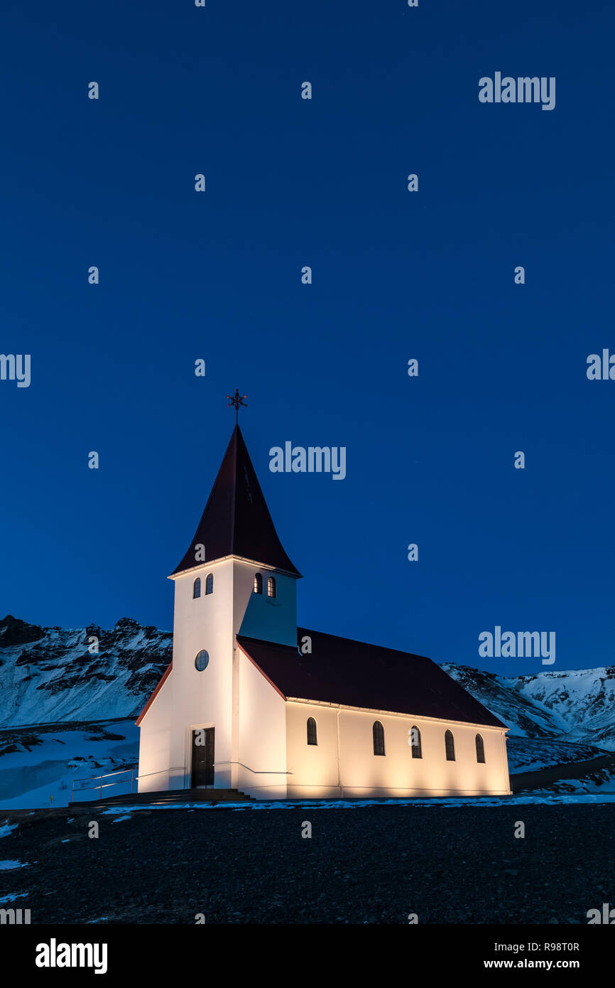 The beautifully illuminated Vik Church stands dramatically over the ...