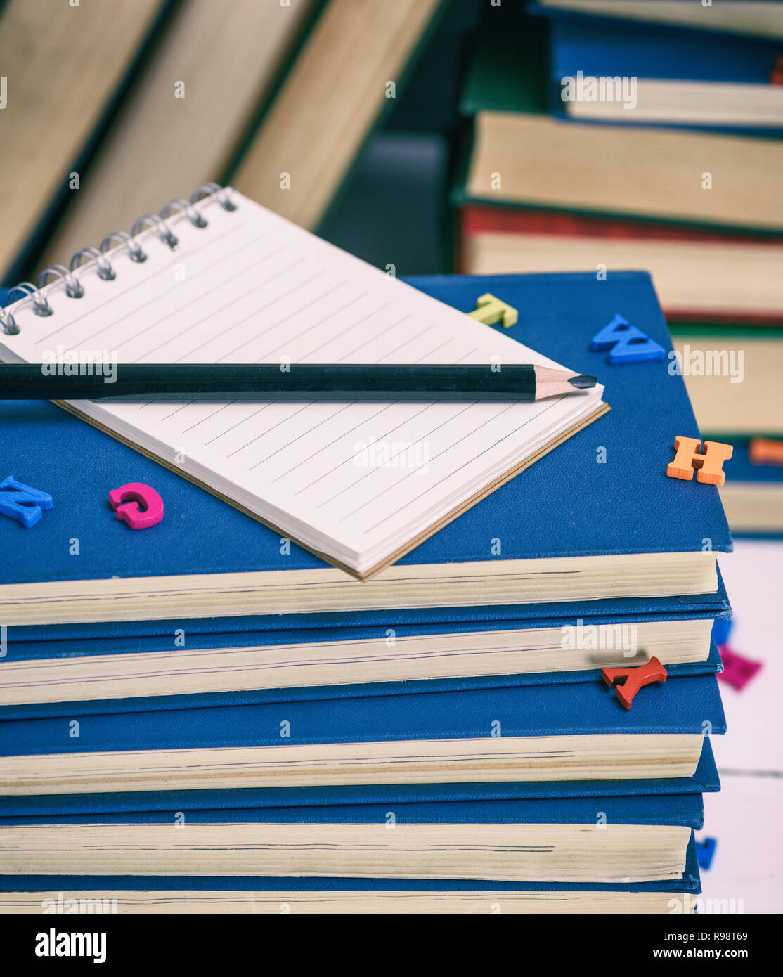 empty notebook with white sheets and many different books, close up ...