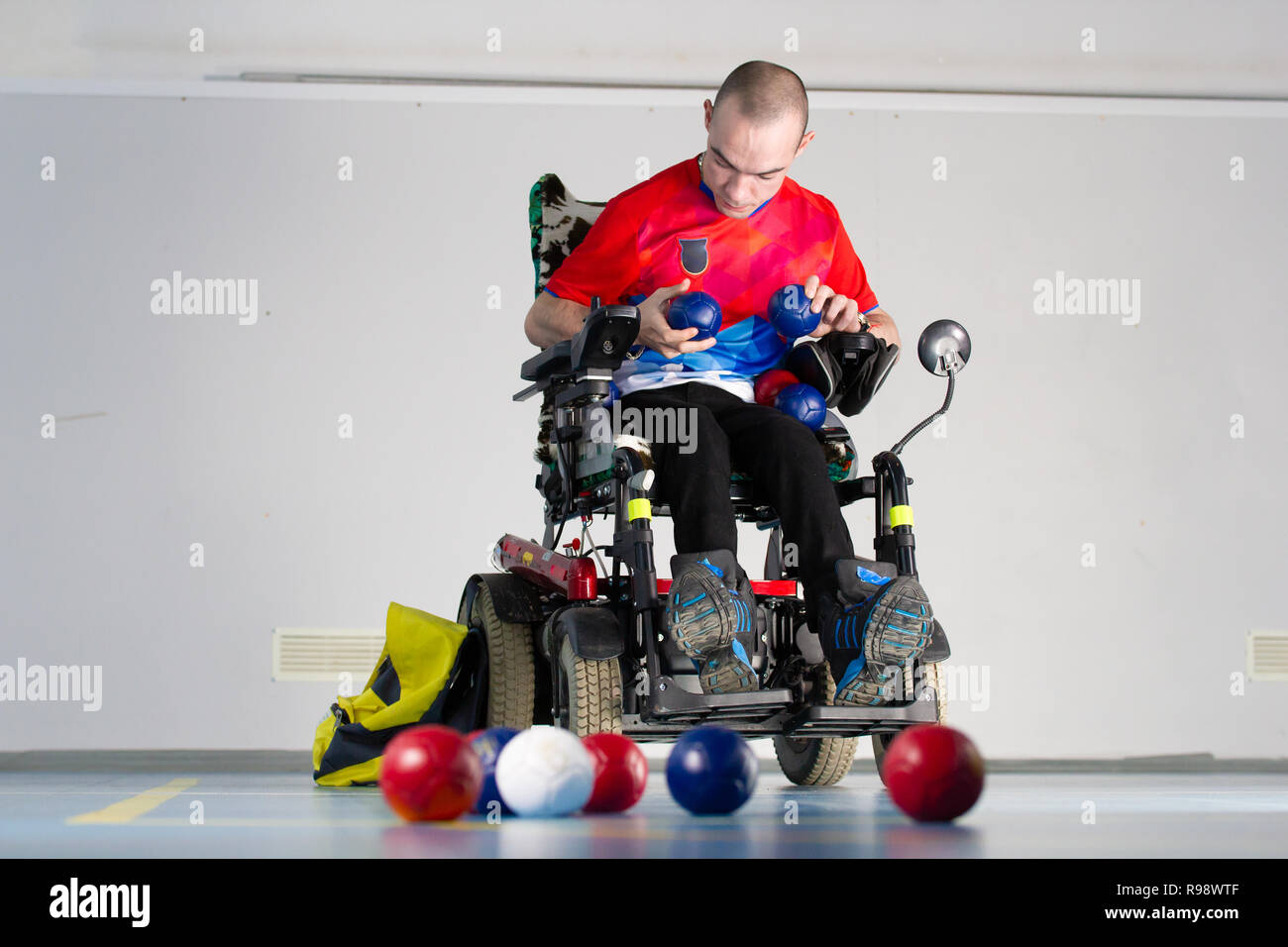 Boccia. A disabled sportsman sitting in a wheelchair holding little ...