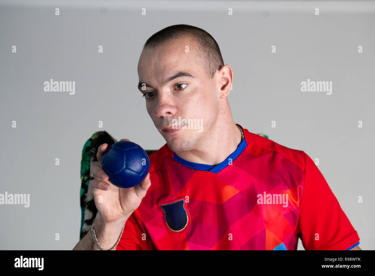 Boccia. A disabled sportsman sitting in a wheelchair holding a little ...