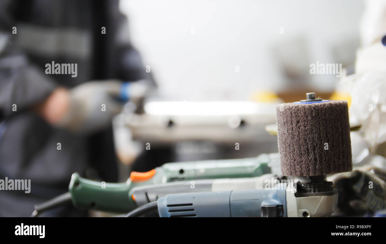 Industrial manufacturing. A man worker on fabric. Sanding machine in ...