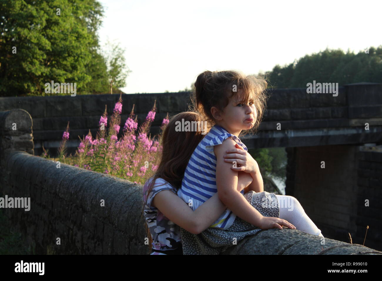 two children looking out at the peak district sat on a wall Stock Photo ...