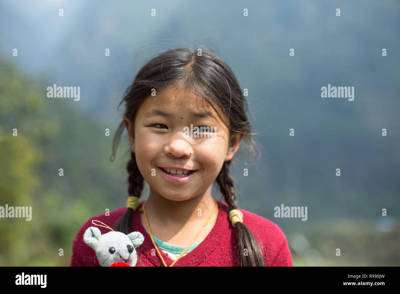 Himalayan girl pose for camera with stuffed toy and smile Stock Photo ...
