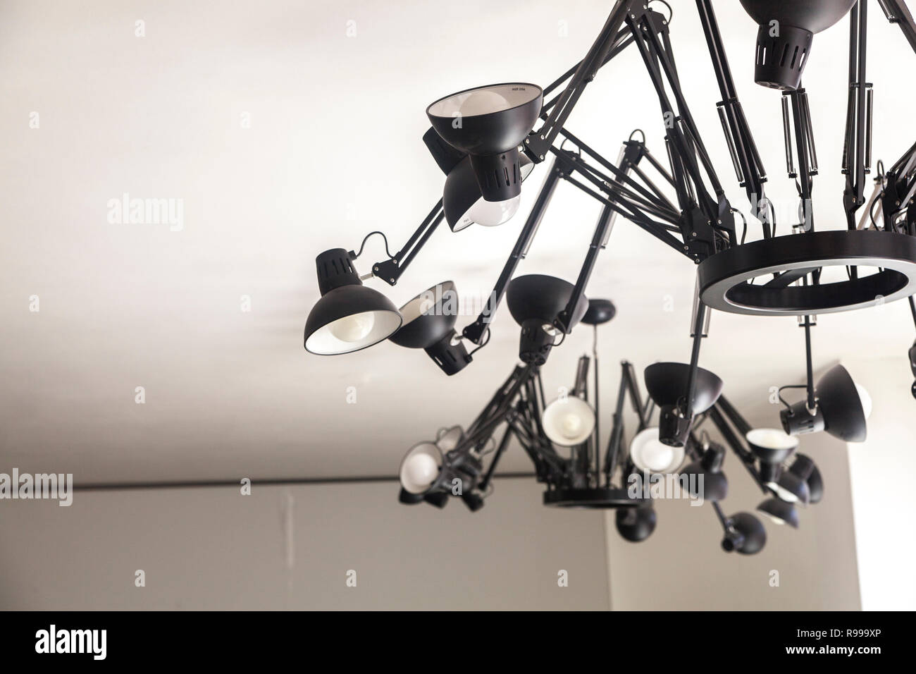 Desktop lamps made in to chandelier hanging from white ceiling Stock ...