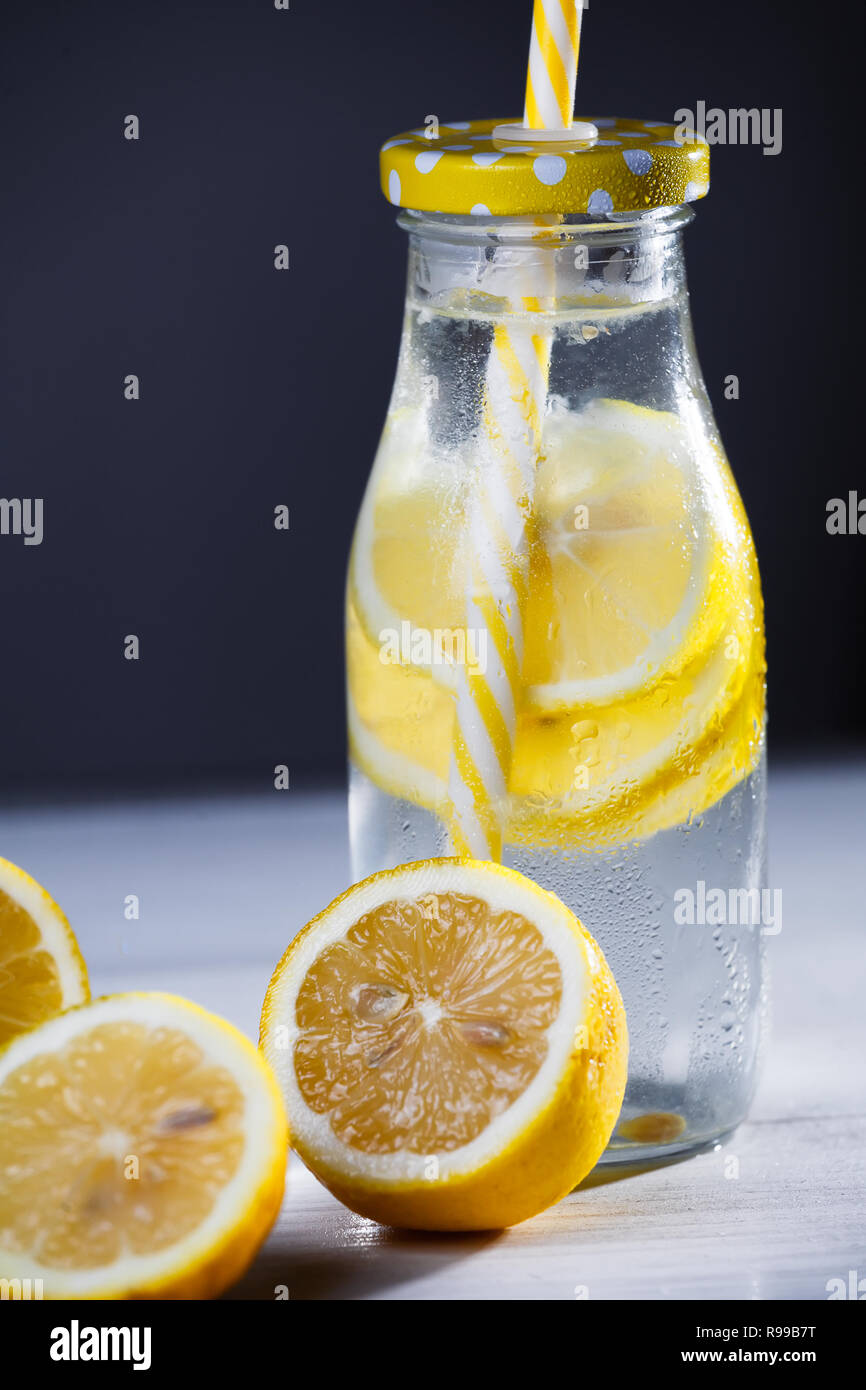 Yellow bottle of lemonade with lemons and straw. Bunch of fruits. White ...