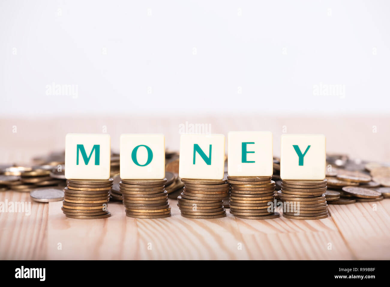 Generic tiles money coins light natural wooden background abstract ...