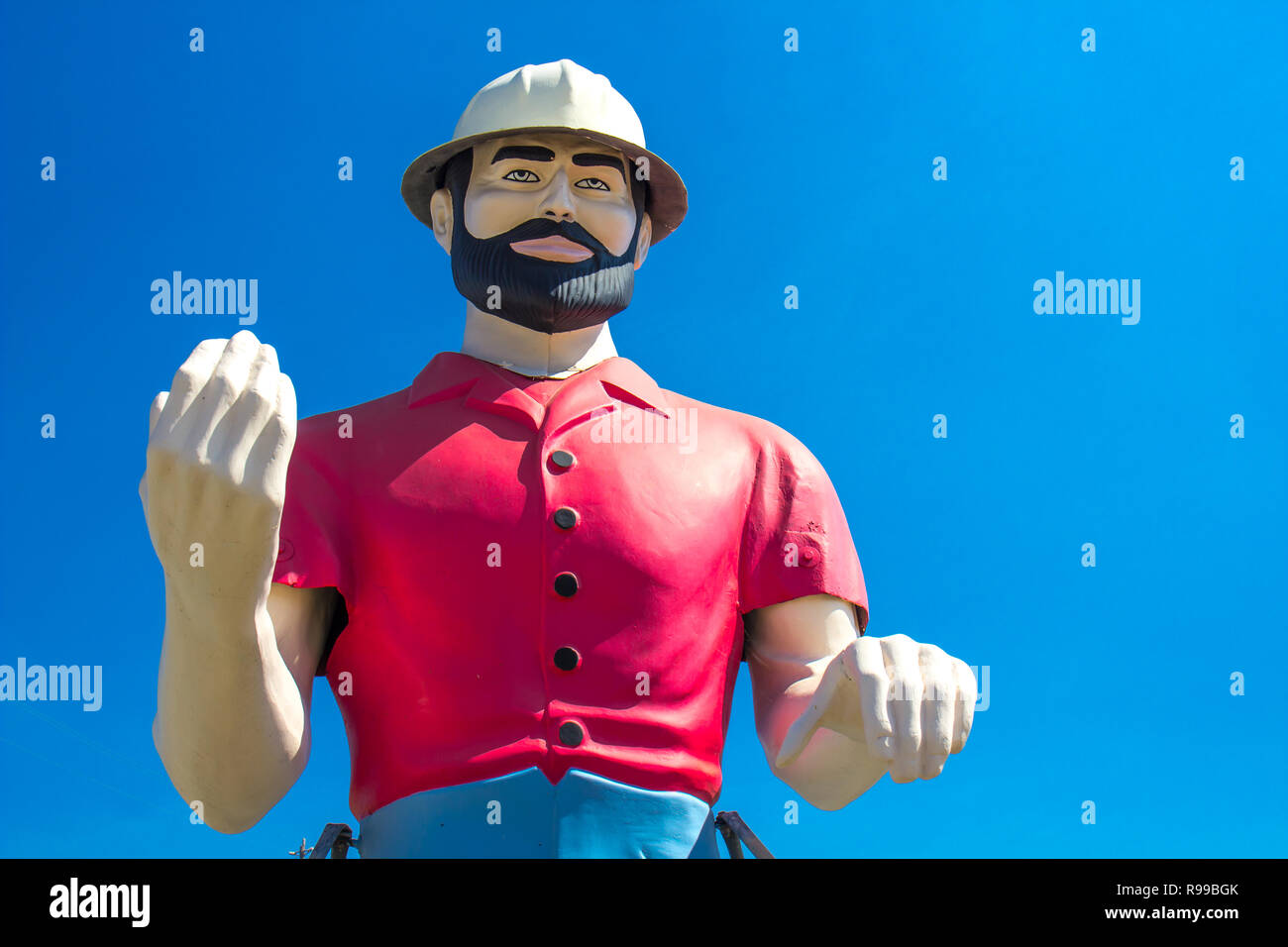Big Man Statue With Helmet And Red Shirt Stock Photo - Alamy