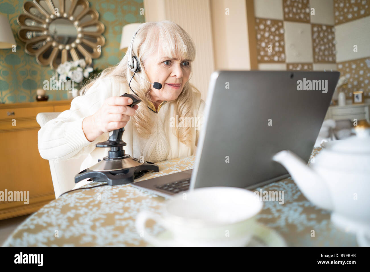 Concentrated Senior Lady In Headphones Is Playing Video Games On Retro ...