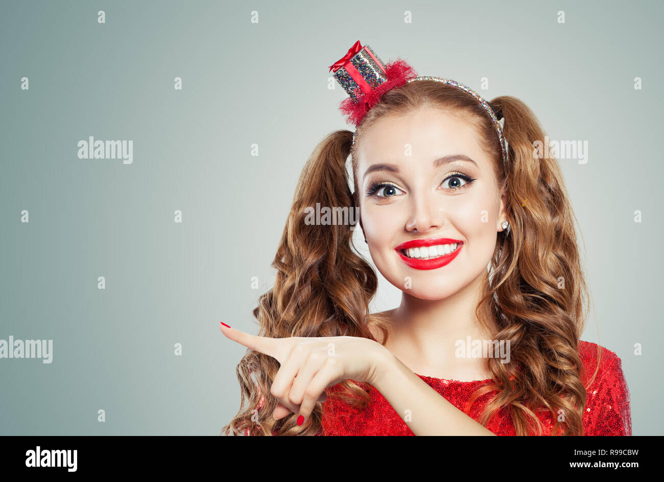 Happy fashion model girl pointing. Beautiful young woman with cute ...