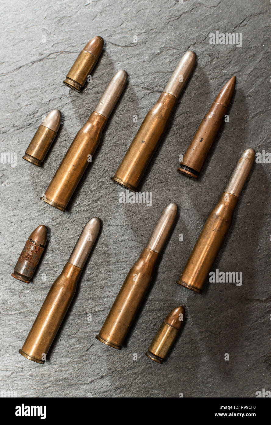 Background of various weapon cartridges ammunitions on stone dark base ...