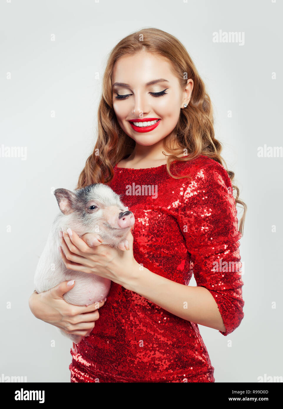 Cute woman fashion model in red dress with little pig on white ...