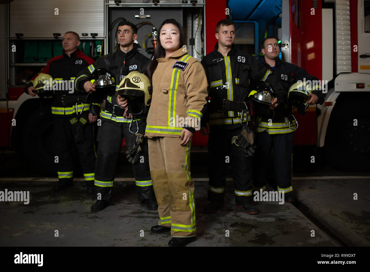 Picture of four young male and female firefighters on background of ...