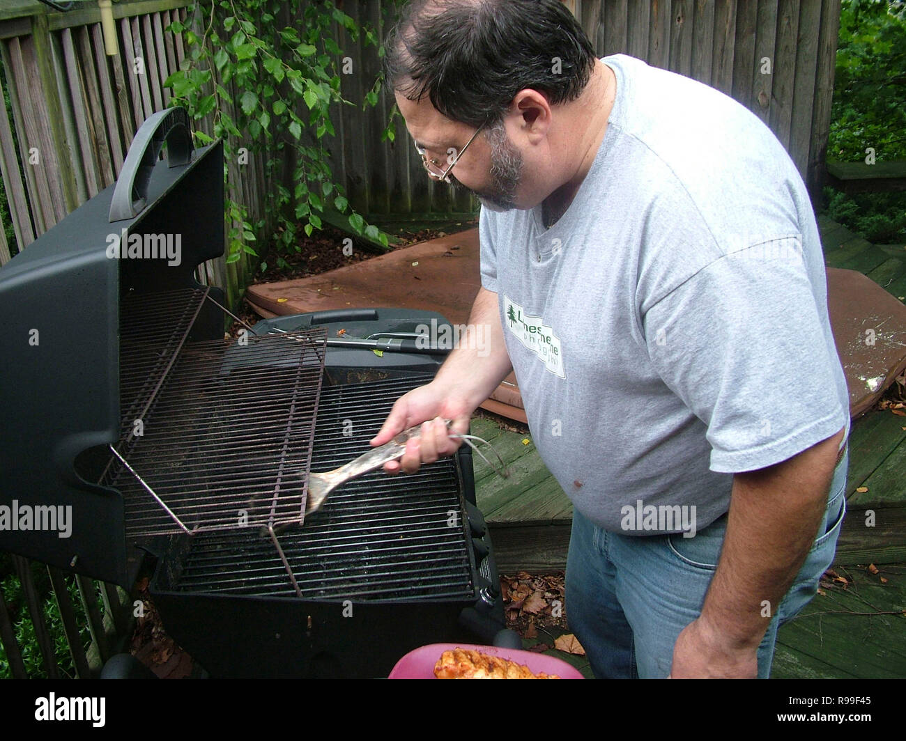 man cleaning grill Stock Photo - Alamy