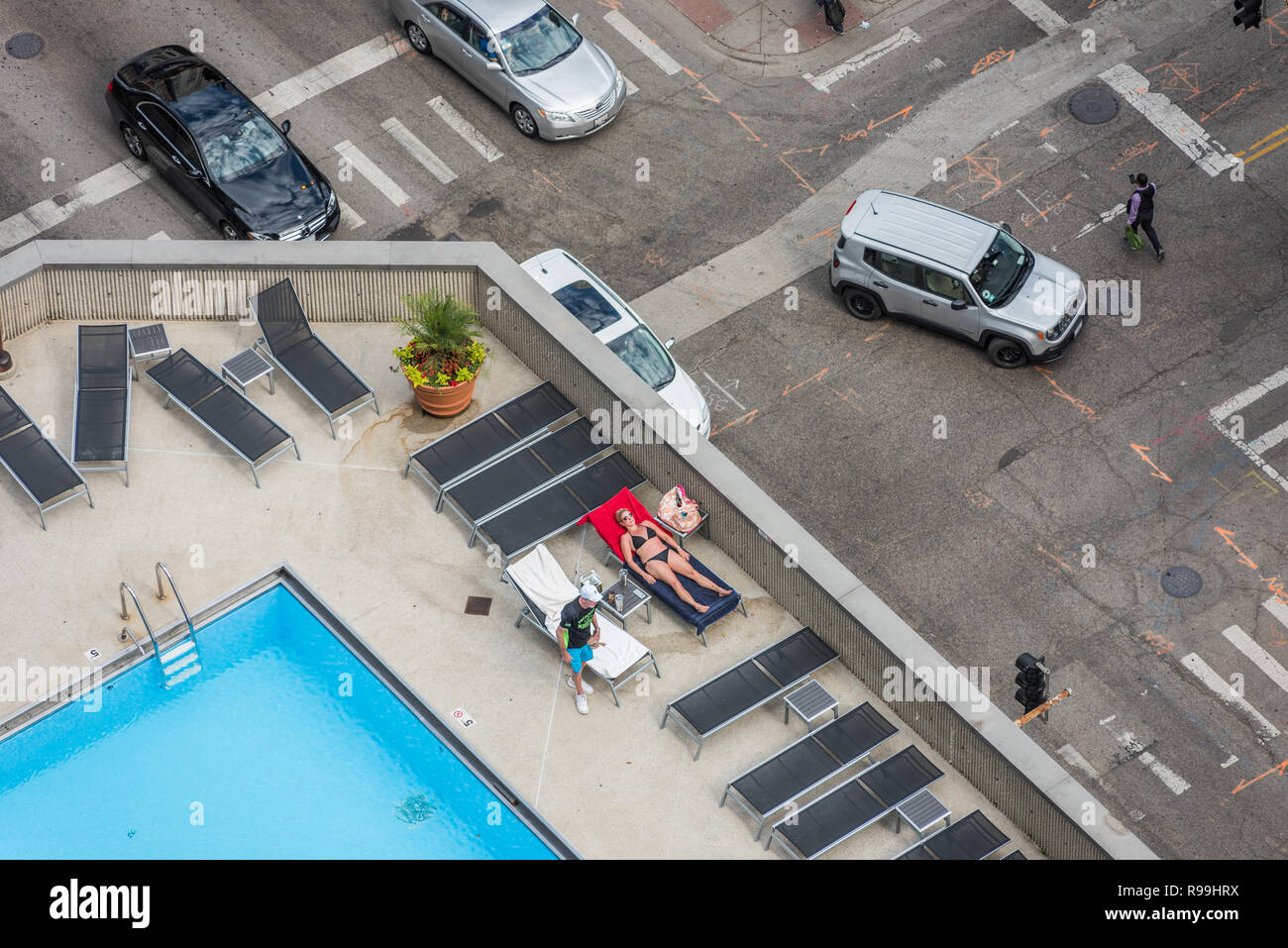 Aerial view of woman sunbathing on pool deck of highrise condo Stock ...