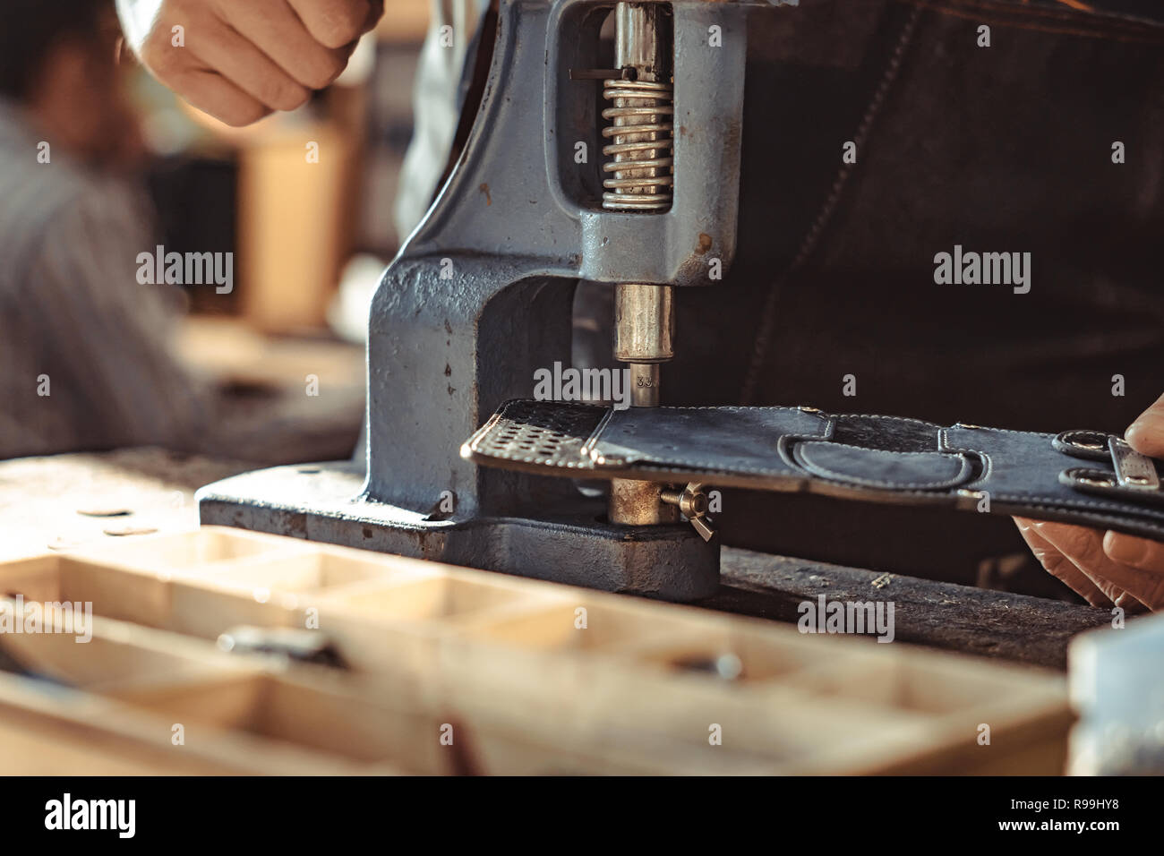 Man works in carpentry workshop. He fixes wooden handle in vice ...