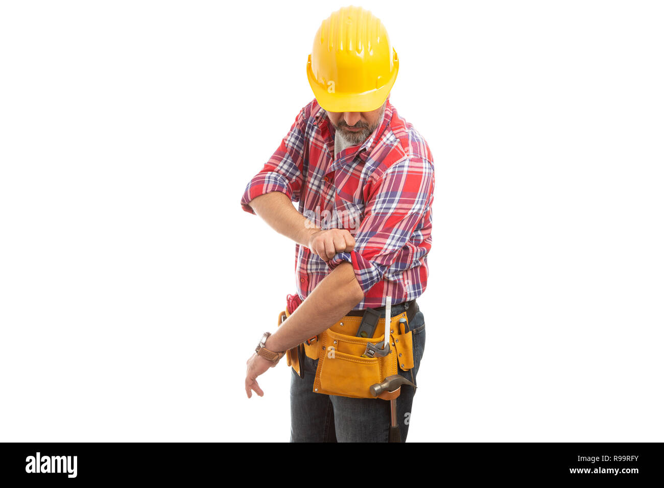 Constructor looking as rolling up plaid shirt sleeve preparing for work ...