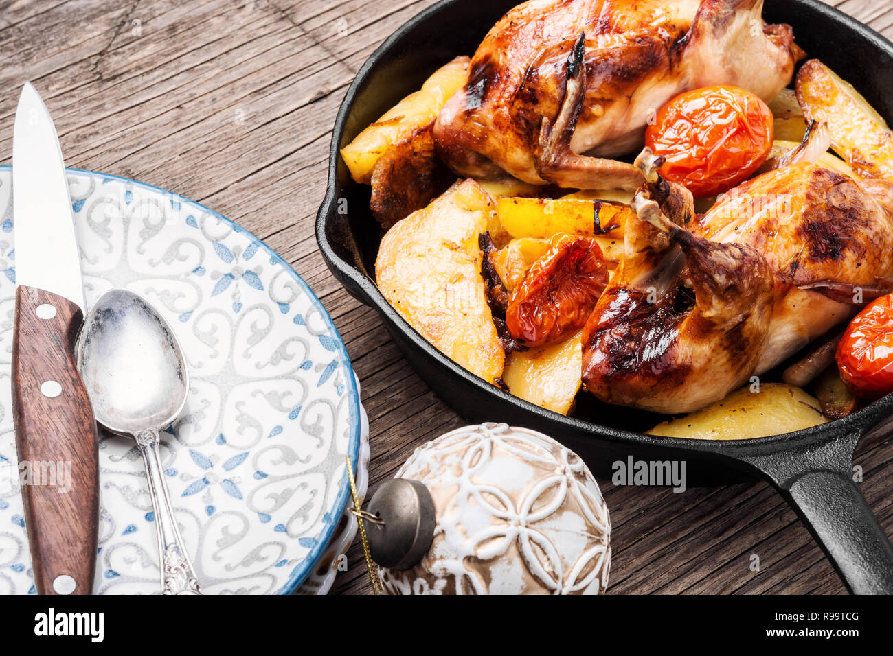 Quail baked with a garnish of potatoes in pan.Christmas meat dish Stock ...