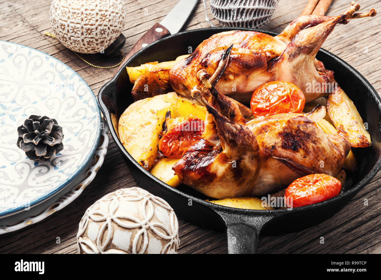Quail baked with a garnish of potatoes in pan.Christmas meat dish Stock ...