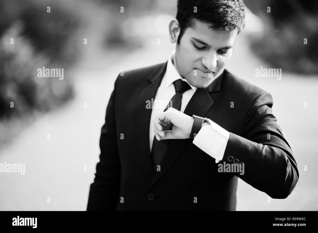 Elegant south asian indian business man in black suit looking at his ...