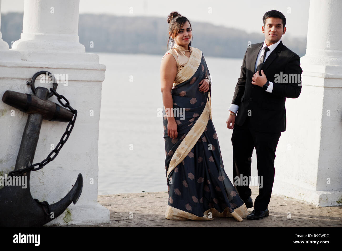 Elegant and fashionable indian friends couple of woman in saree and man ...