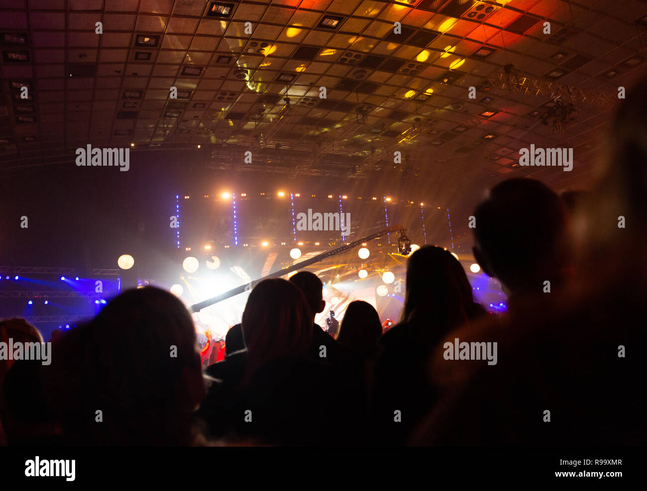 Silhouette of a concert crowd. The audience looks towards the stage ...