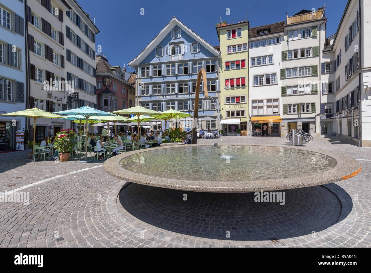 Munsterhof square with fountain and colorful buildings with cafe and ...