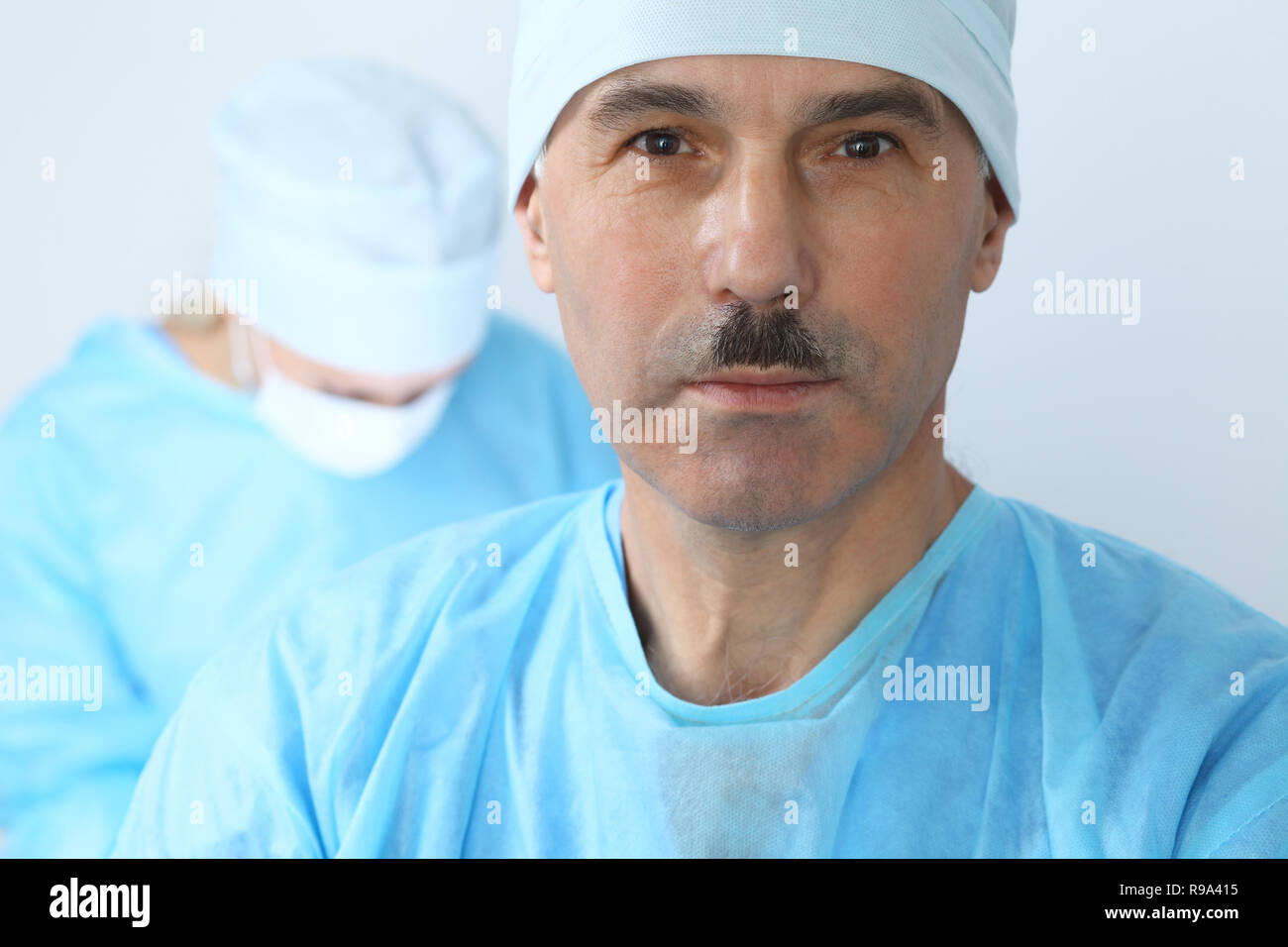 Boss surgeon is examining the operation while medical team are busy of ...