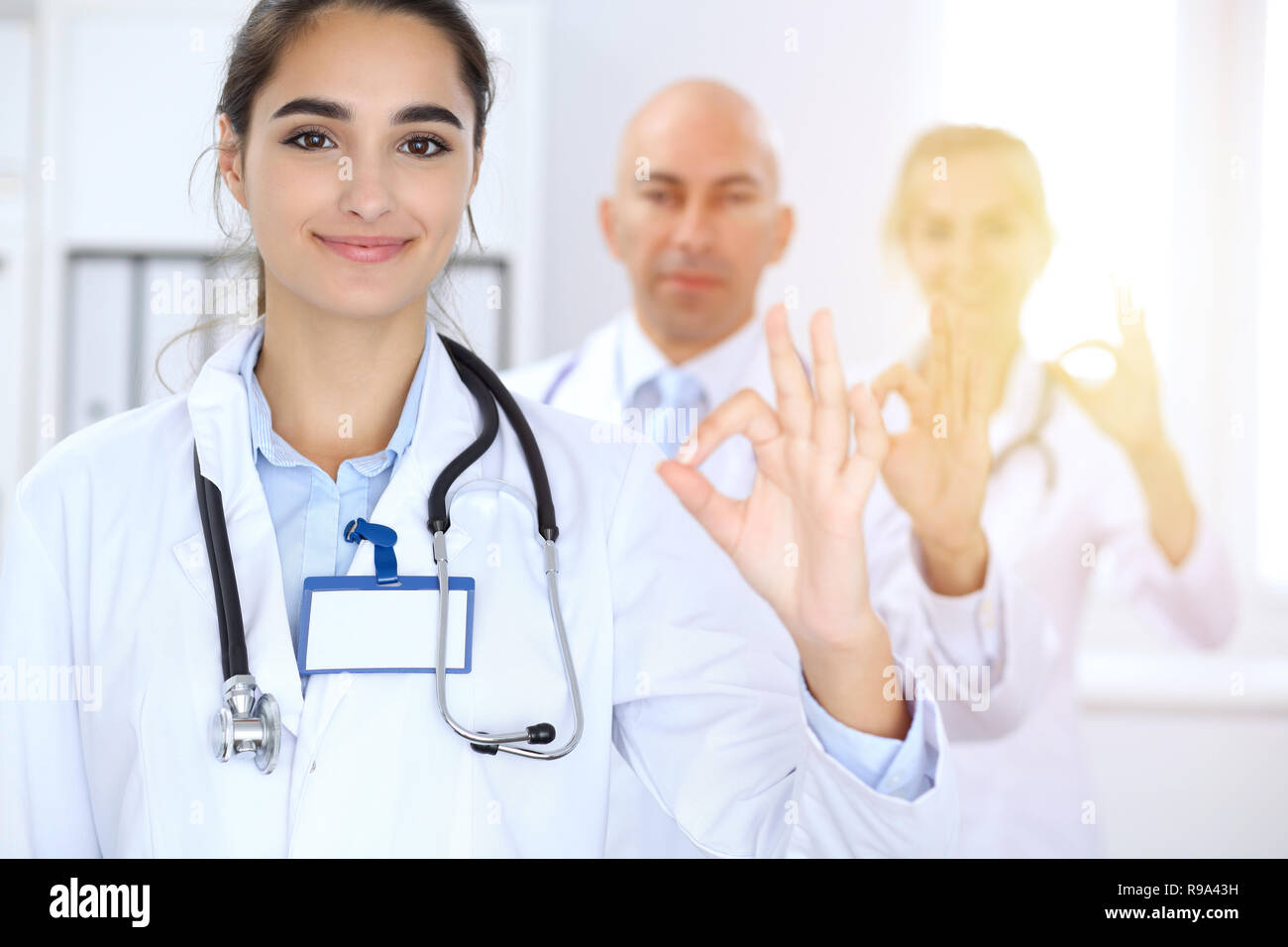 Group of doctors showing OK or approval sign with thumb up. High level ...