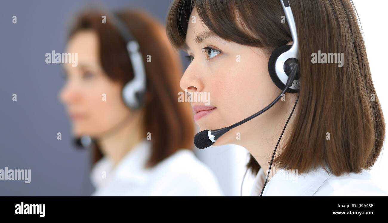 Call center. Group of operators at work. Focus on young brunette woman. Business concept Stock ...