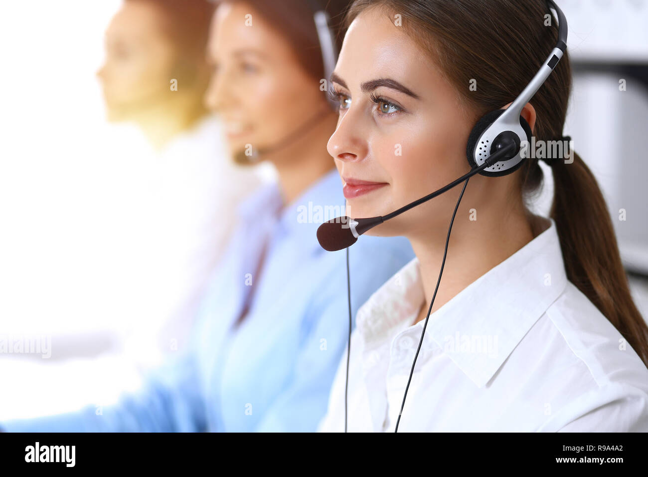Call center. Group of operators at work. Focus at beautiful business woman in headset Stock ...