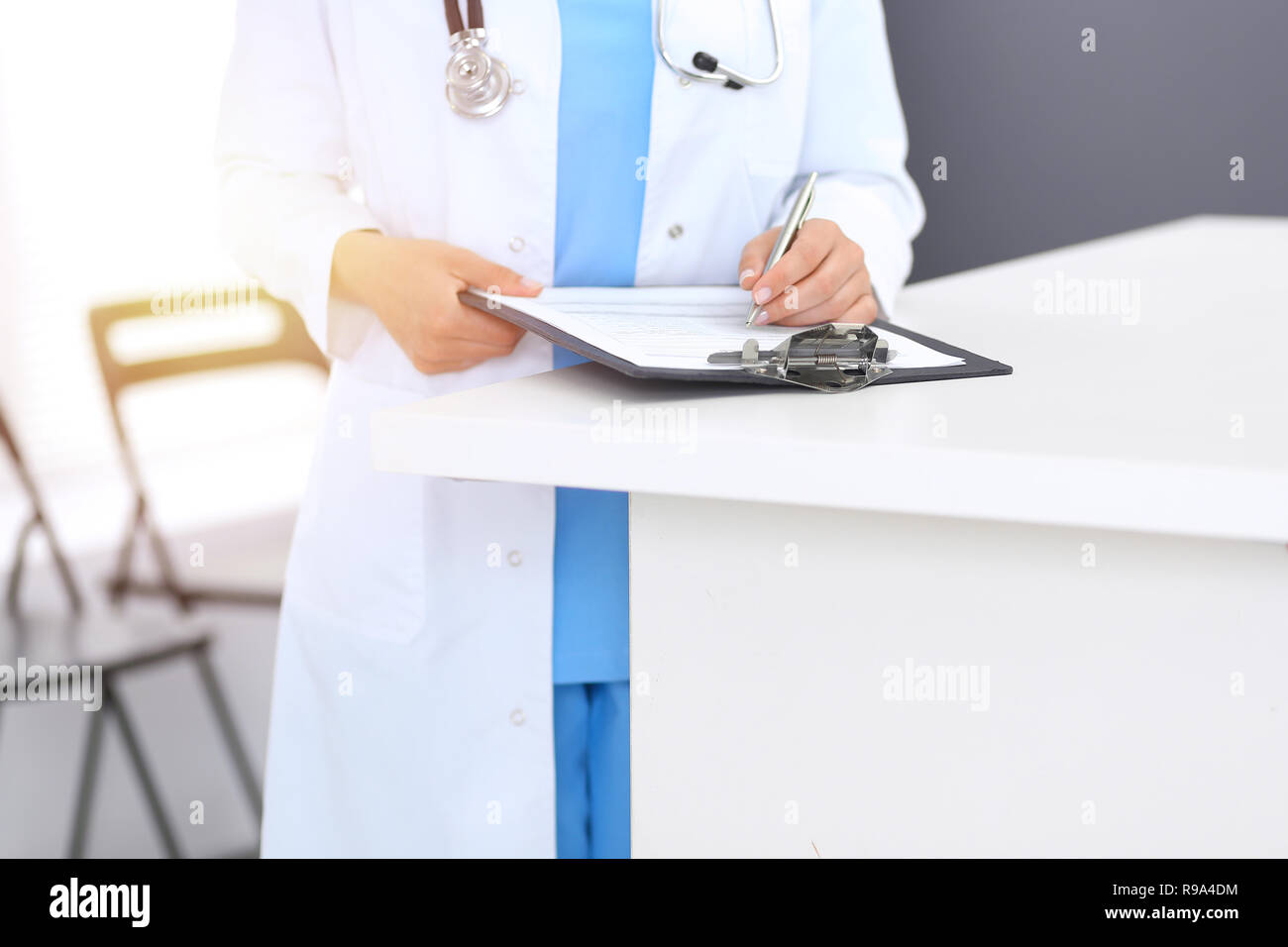 Unknown doctor woman at work, hands close-up. Female physician filling ...